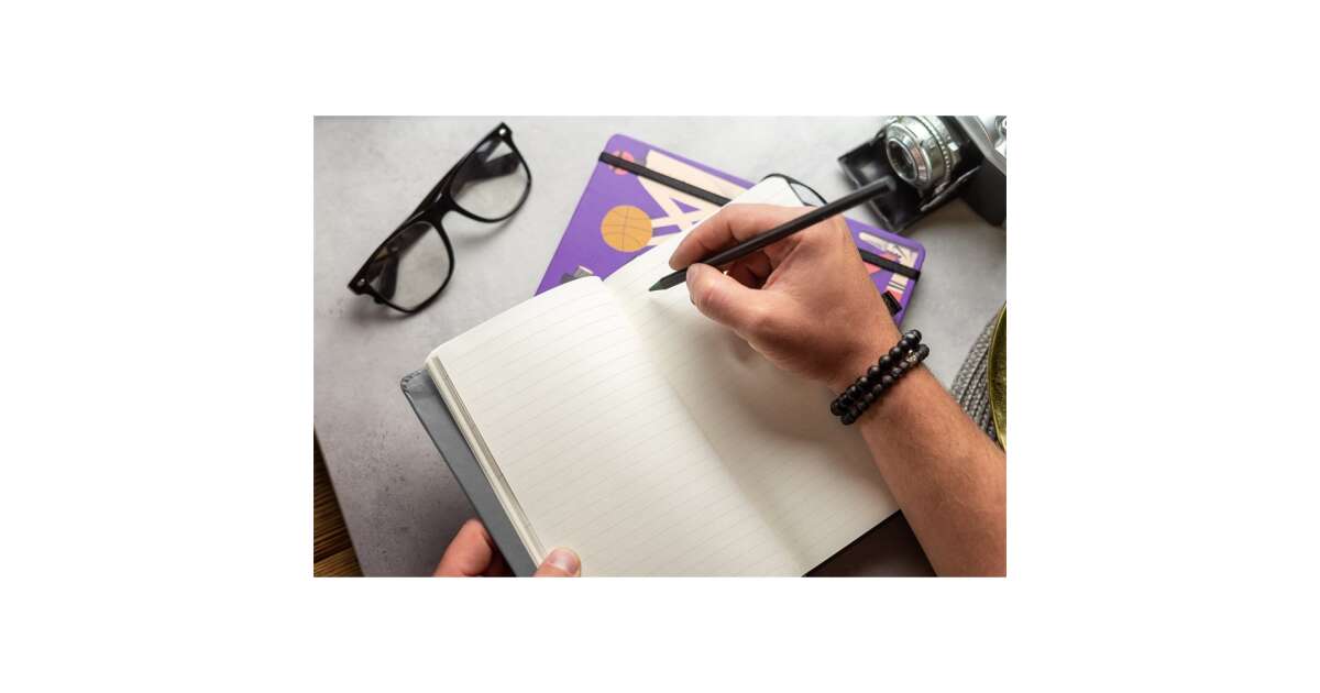 Hardboard notebook with lined cream coloured pages with rubber band ...